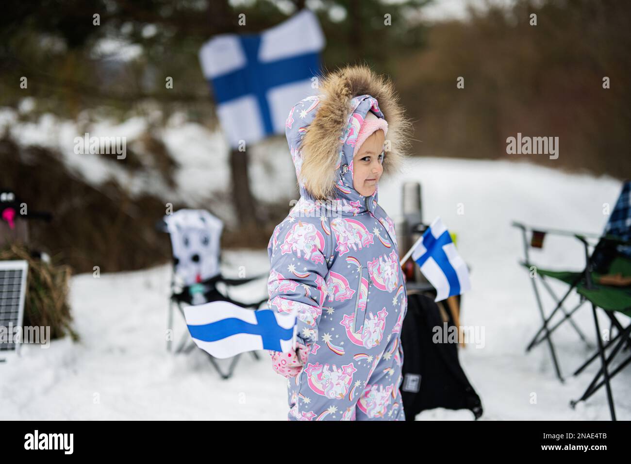 Finnish baby girl with Finland flags on a nice winter day. Nordic ...