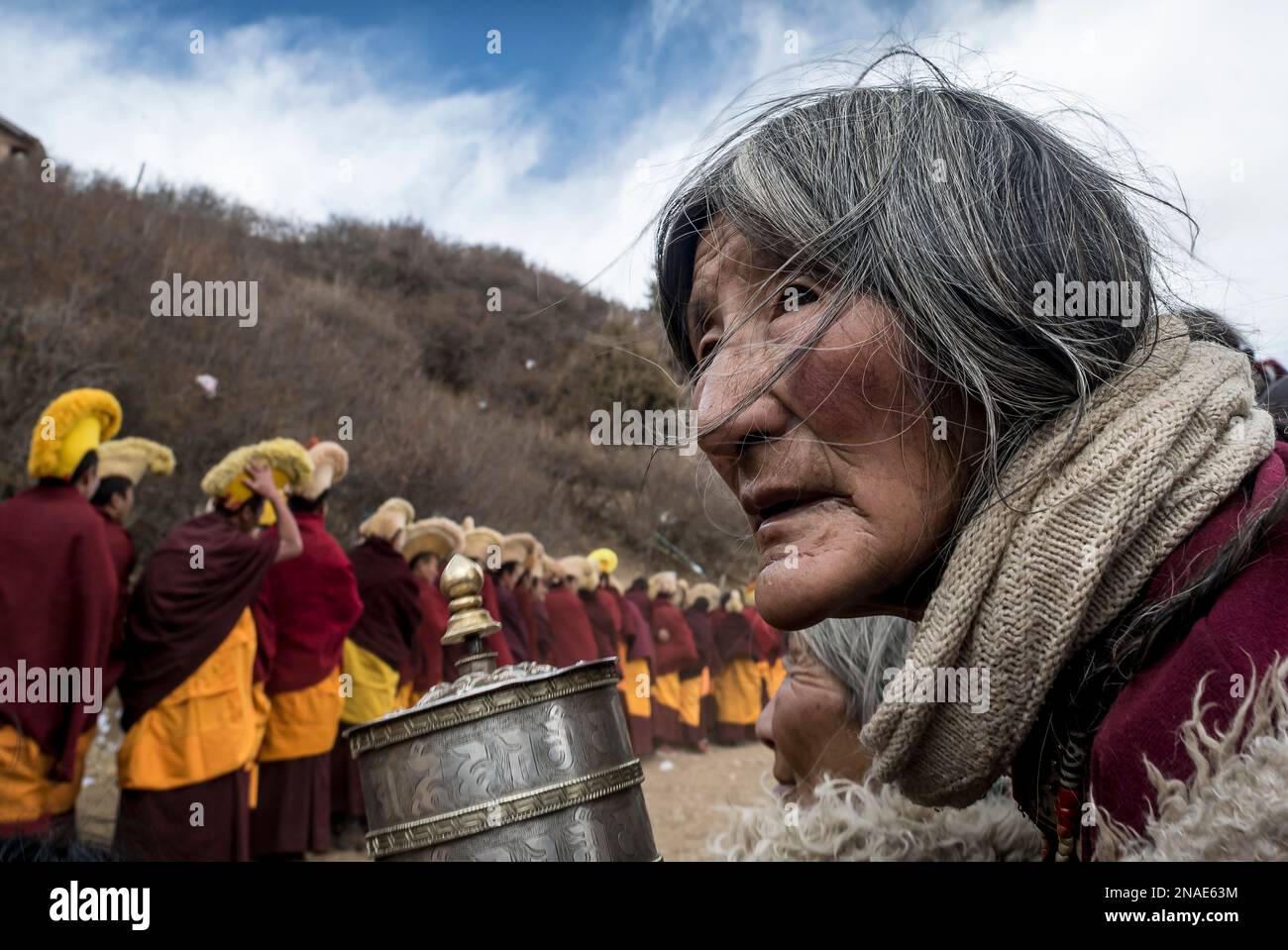 Pilgrim with prayer wheel and monk behind Stock Photo - Alamy