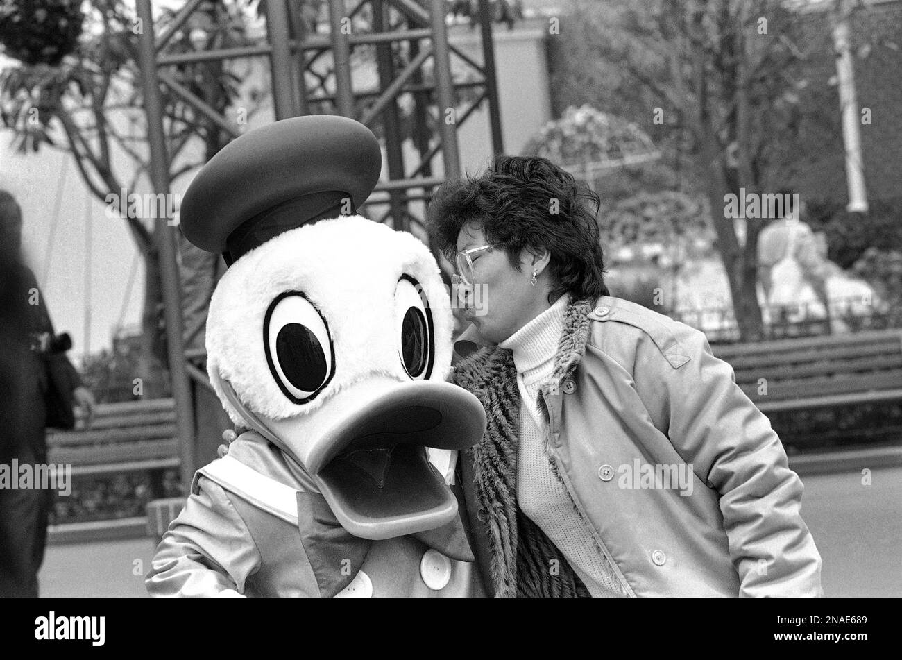 An invited guest plants a kiss on the cheek of Donald Duck at Tokyo ...