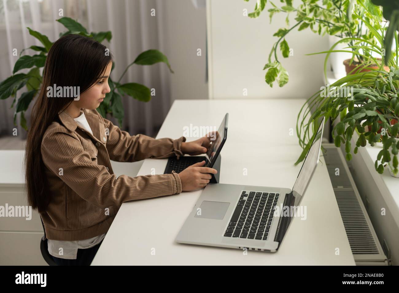 School teen girl student wears headphones distance learning with online ...