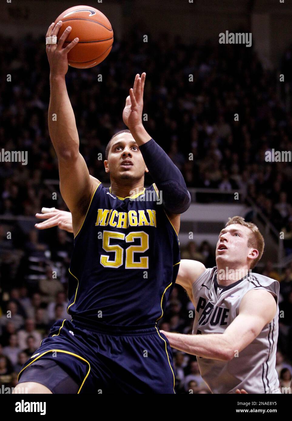 Michigan forward Jordan Morgan, left, makes a basket in front of Purdue ...