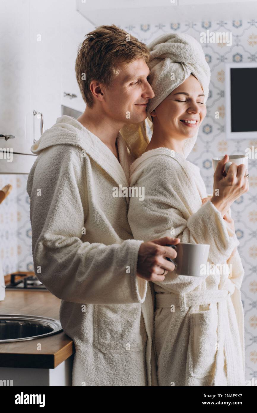 A couple in white terry bathrobes with cups in their hands Stock Photo ...