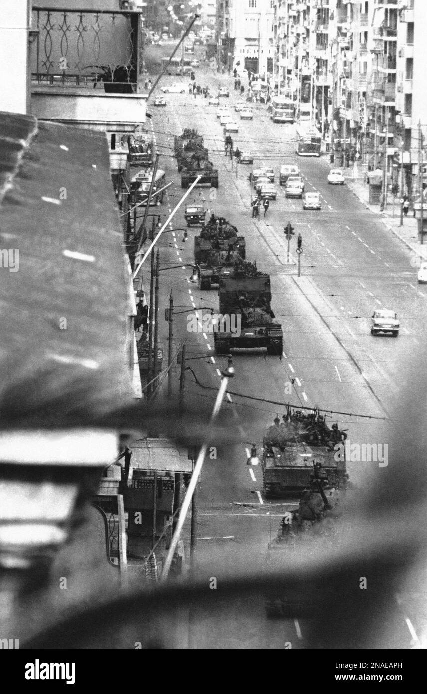 Tanks and troop-carrying armoured vehicles rumble down Patission Avenue ...