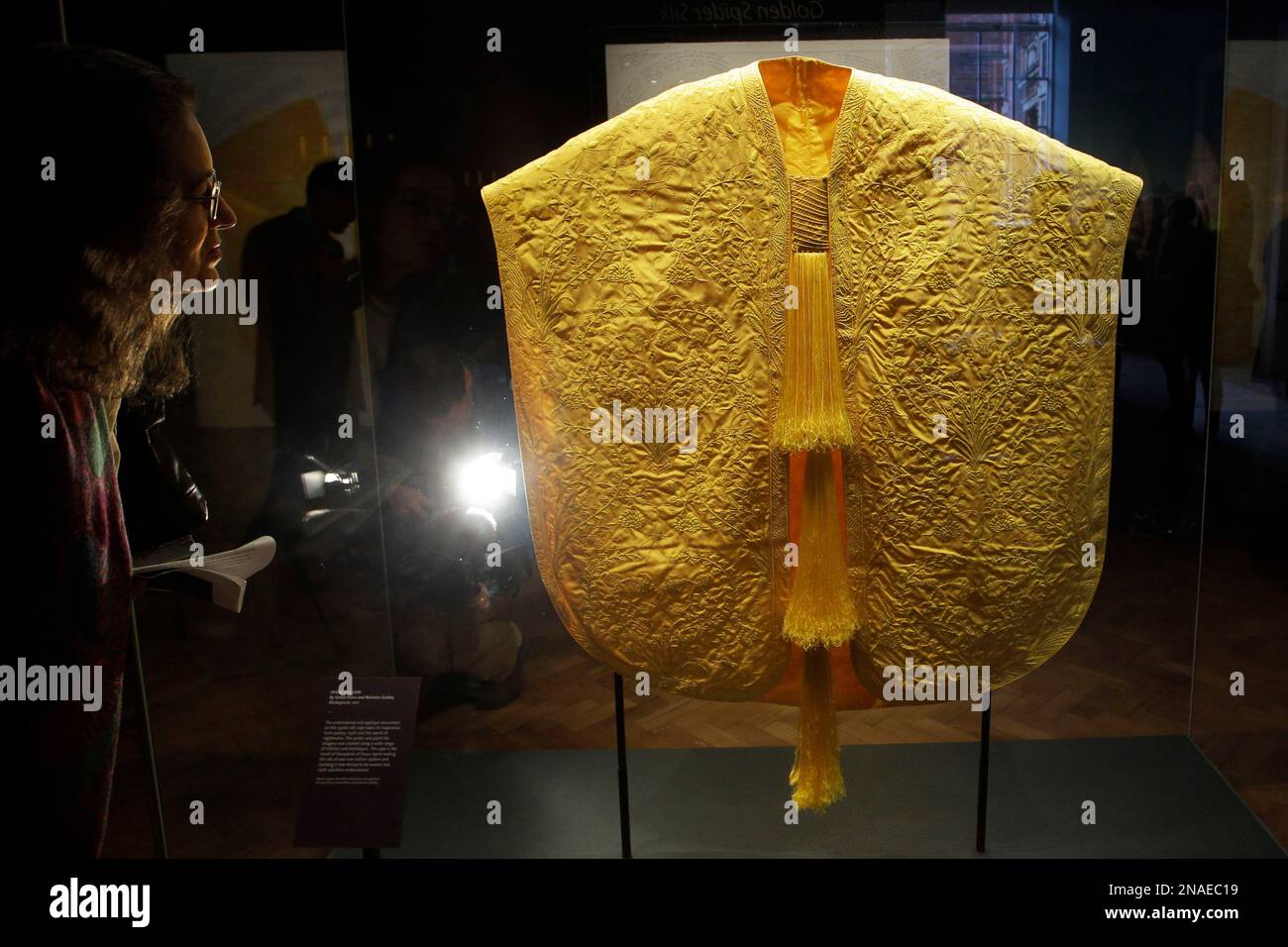 Visitors look at a spider silk cape, designed by Simon Peers and ...