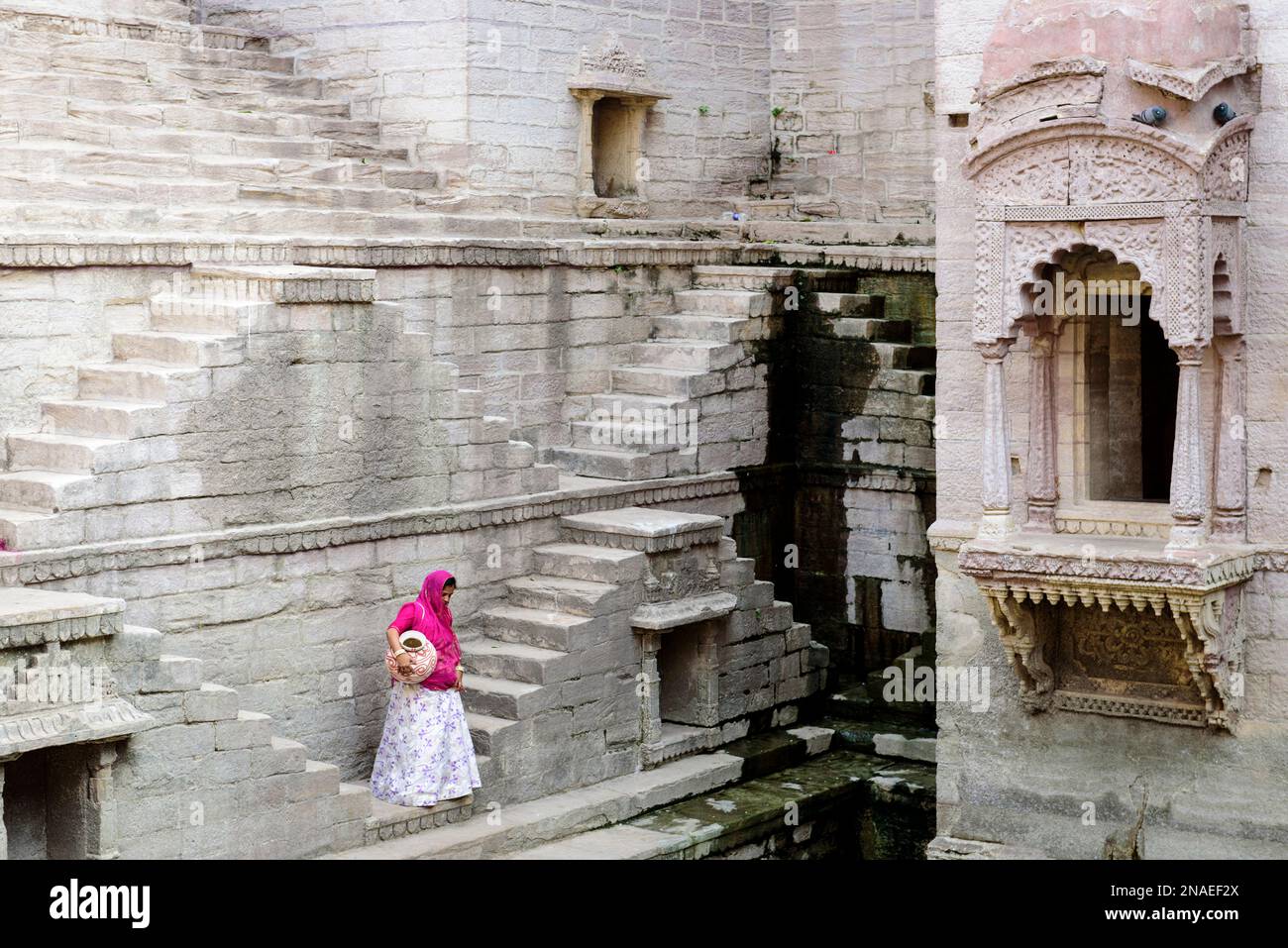 Woman collecting water from step well Stock Photo - Alamy