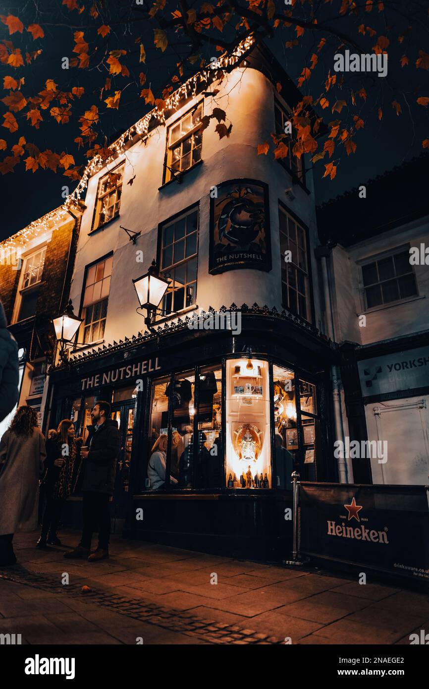 A group of people chatting by The Nutshell the smallest pub at night ...