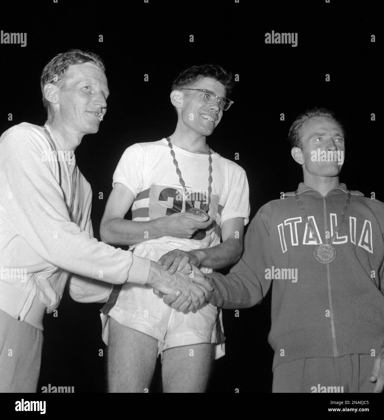 The winners of the Olympic 50 kilometre Walk shake hands on the podium ...