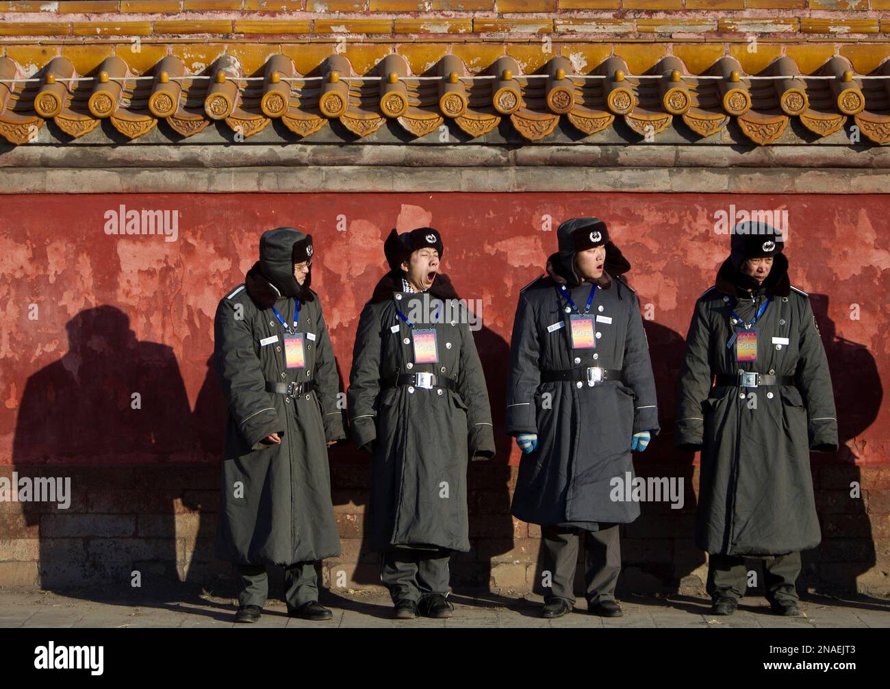 Chinese security guards yawn before proceeding to their duties at a ...