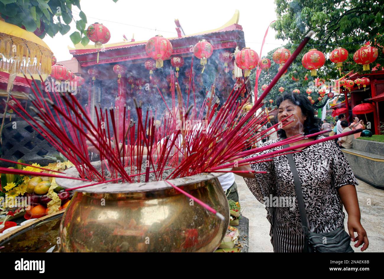Balinese ethnic Chinese burn incense sticks as they pray at a temple to ...