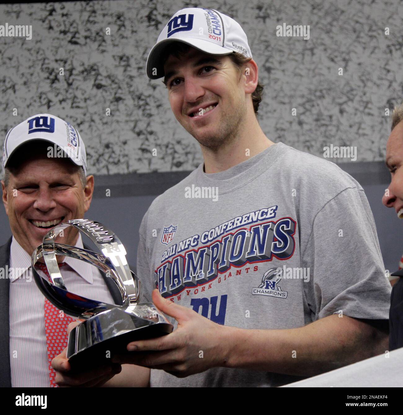New York Giants Eli Manning lifts the George Halas Trophy in the locker ...