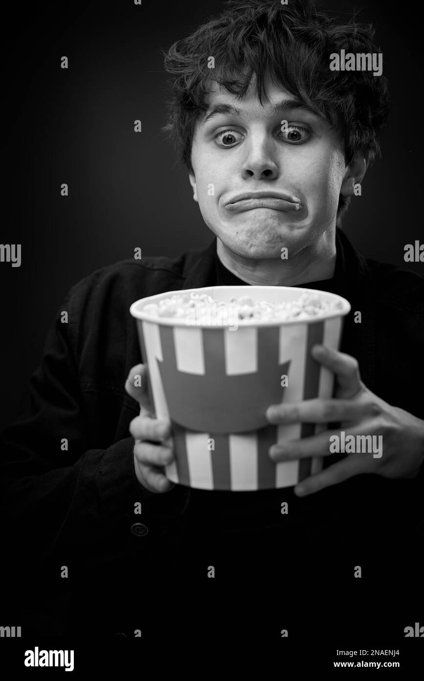 portrait of crazy young man holding bucket of popcorn Stock Photo - Alamy