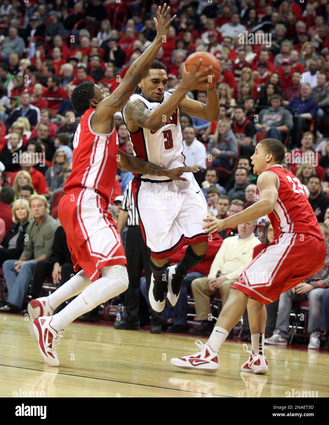 UNLV's Anthony Marshall squeezes between New Mexico's Demetrius Walker ...