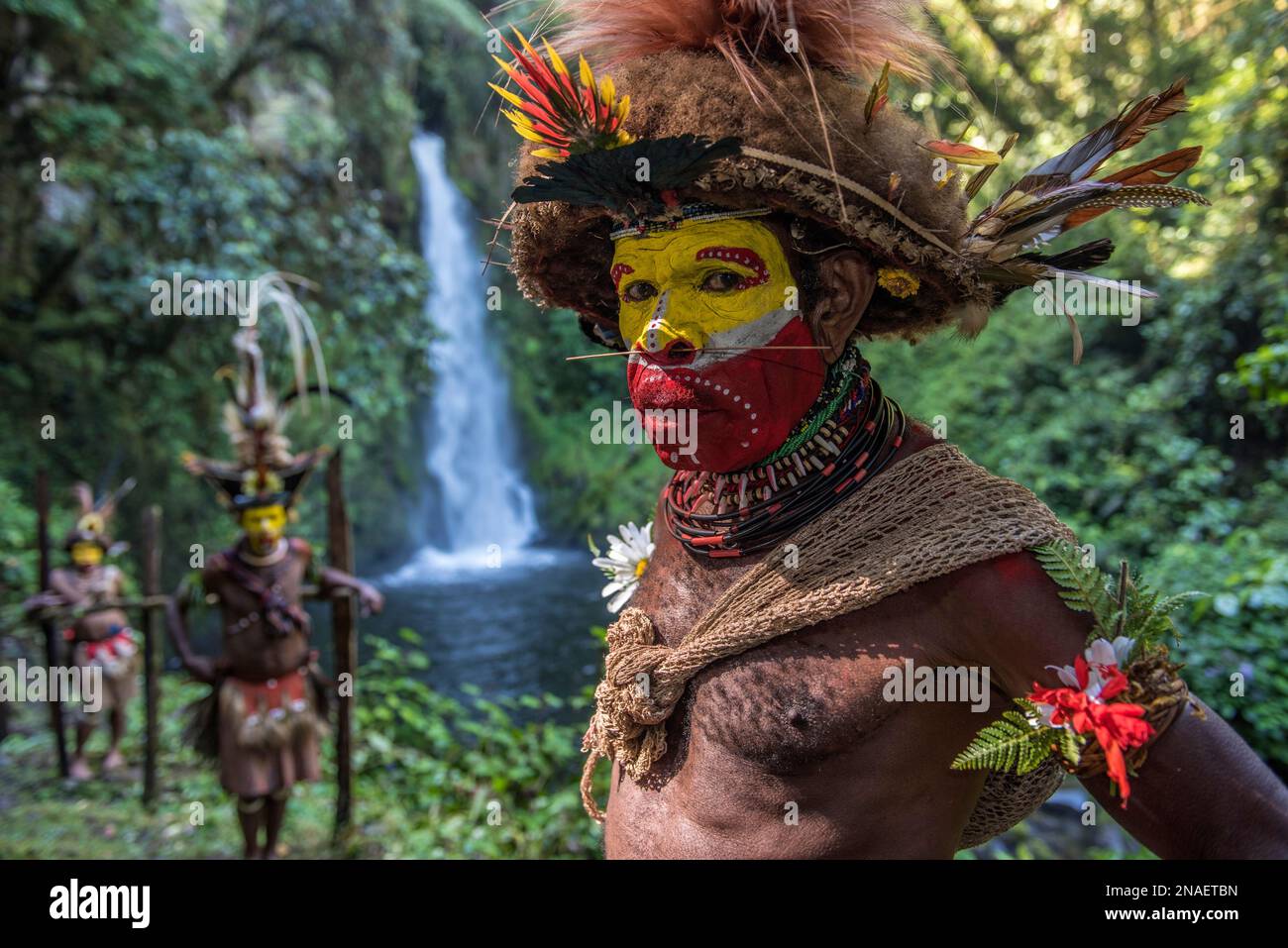 Huli wig men posing by a waterfall behind the Ambusa Lodge in Tigibi ...