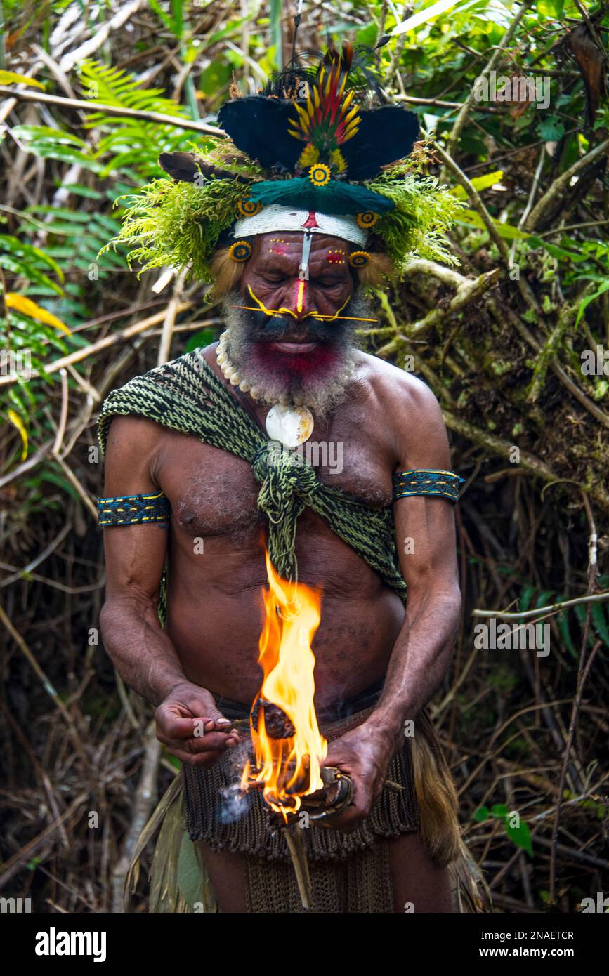 Huli tribesman wearing wig and using fire in the Tari Valley area in ...