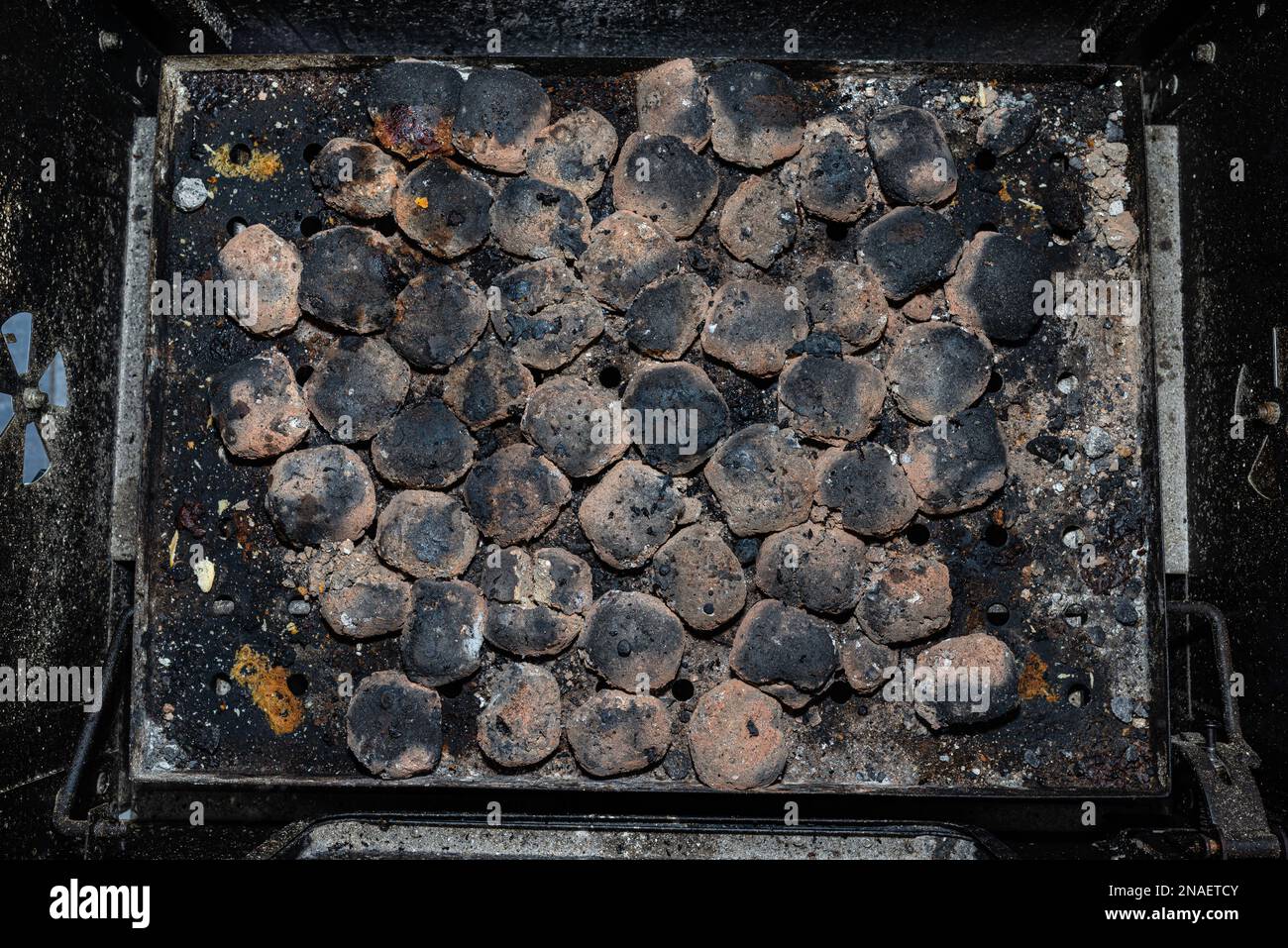 Cleaning a dirty grill while standing on the terrace and emptying the ...