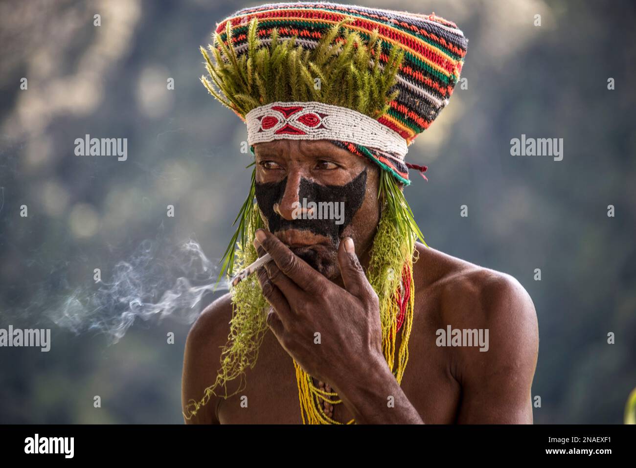 Participant wearing a wig and smoking a cigarette during a Sing Sing, a ...