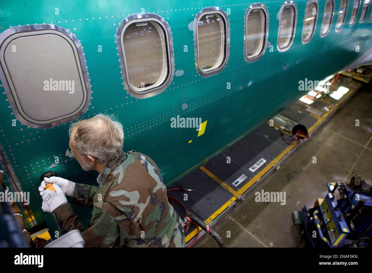 Boeing employees work on a 737 plane engine in Renton, Wash., Tuesday ...
