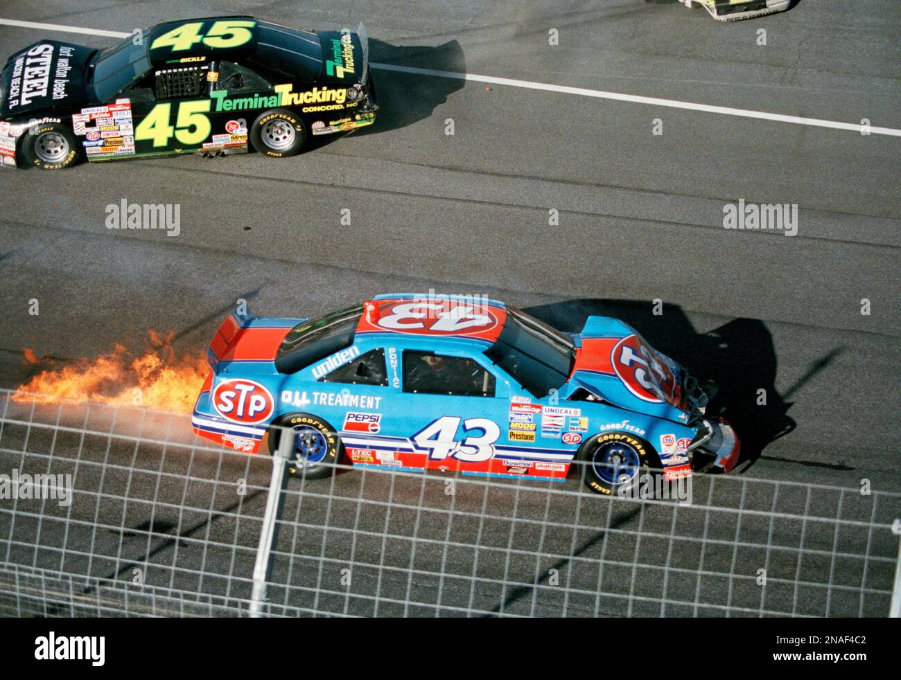 NASCAR driver Richard Petty's car spews flames as Rich Bickle slides ...