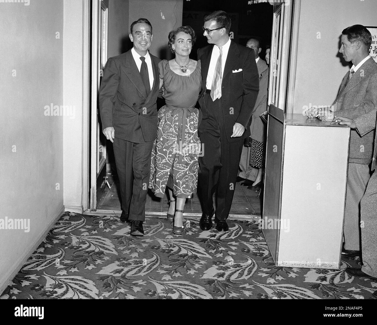 Actress Joan Crawford, escorted by writer Mel Dinelli, left, and actor ...