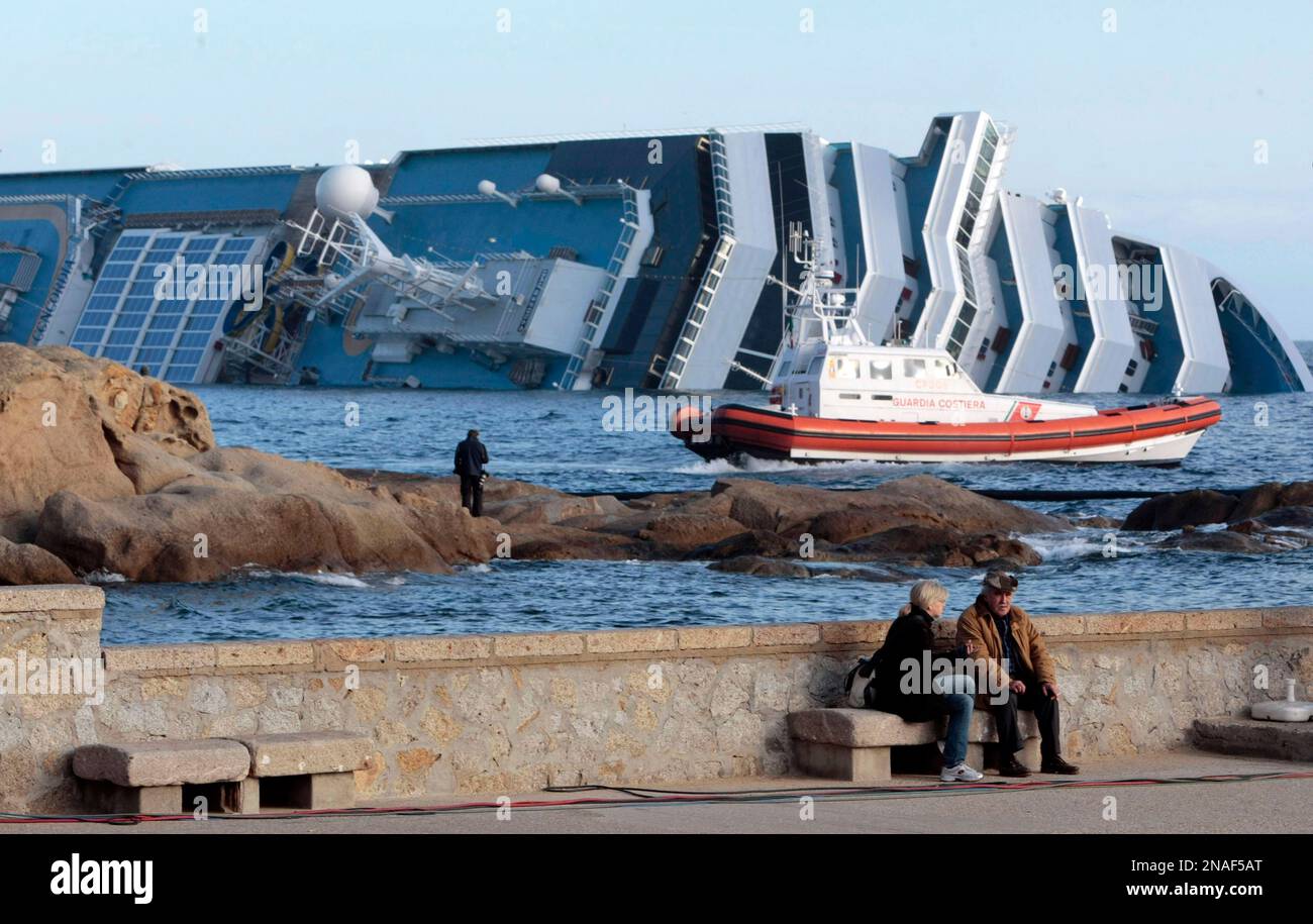The cruise ship Costa Concordia lies on its side off the tiny Tuscan ...