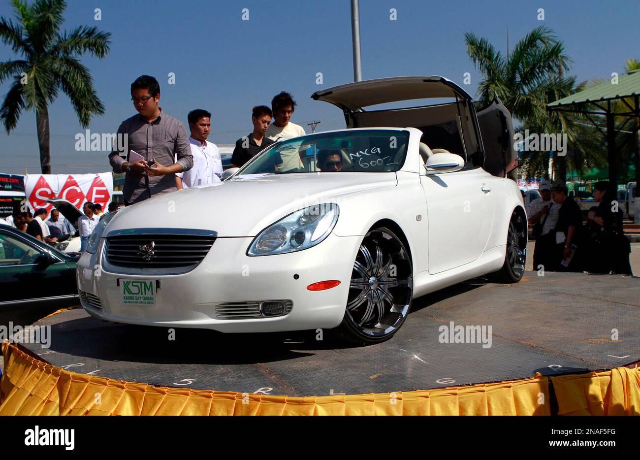 Visitors observe a luxury Toyota convertible on display at the National ...