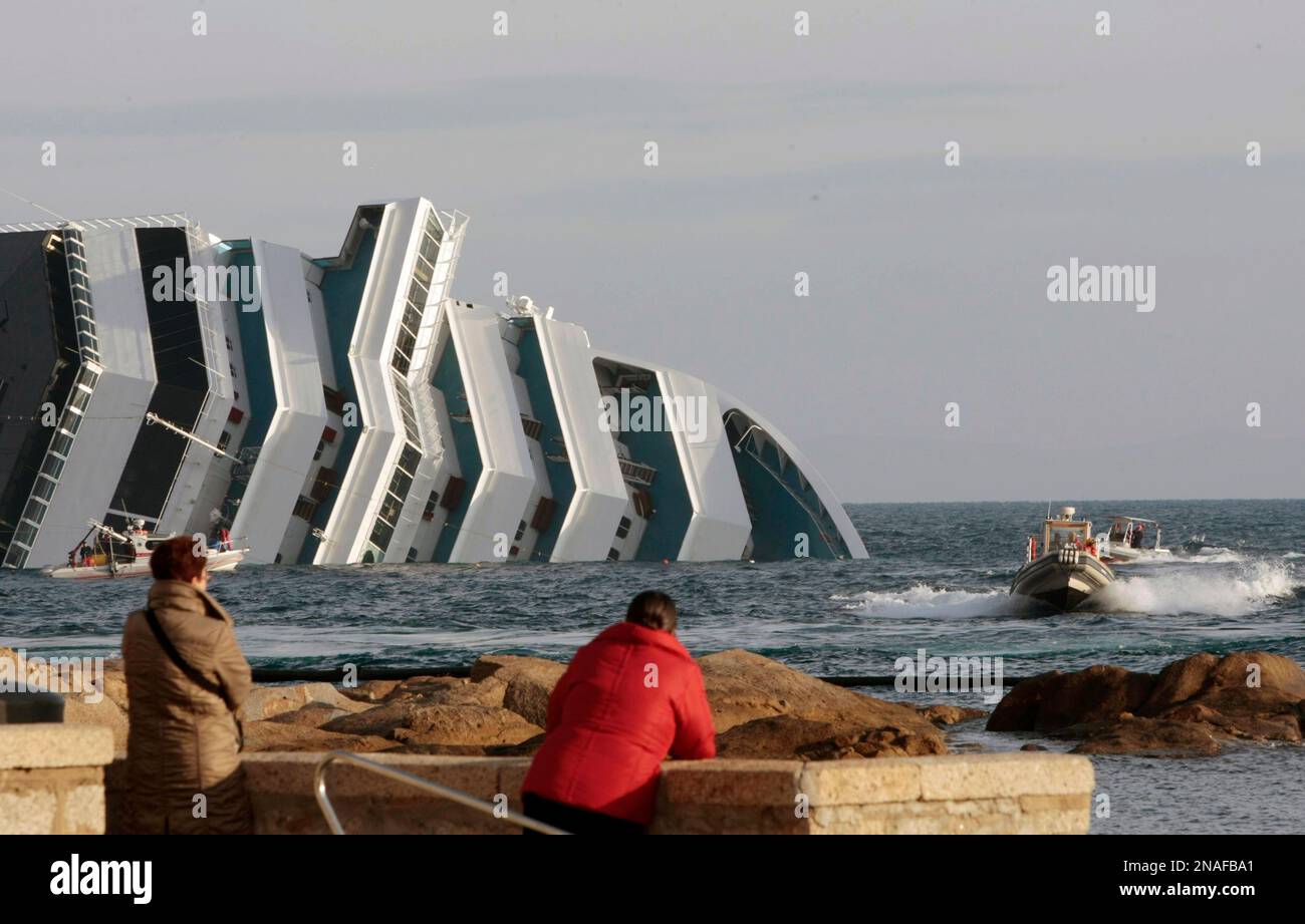 People view the cruise ship Costa Concordia as it lays on its side ...