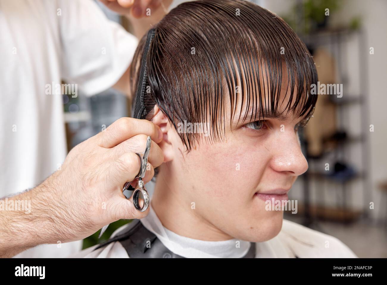 young caucasian man getting haircut by professional male hairstylist ...