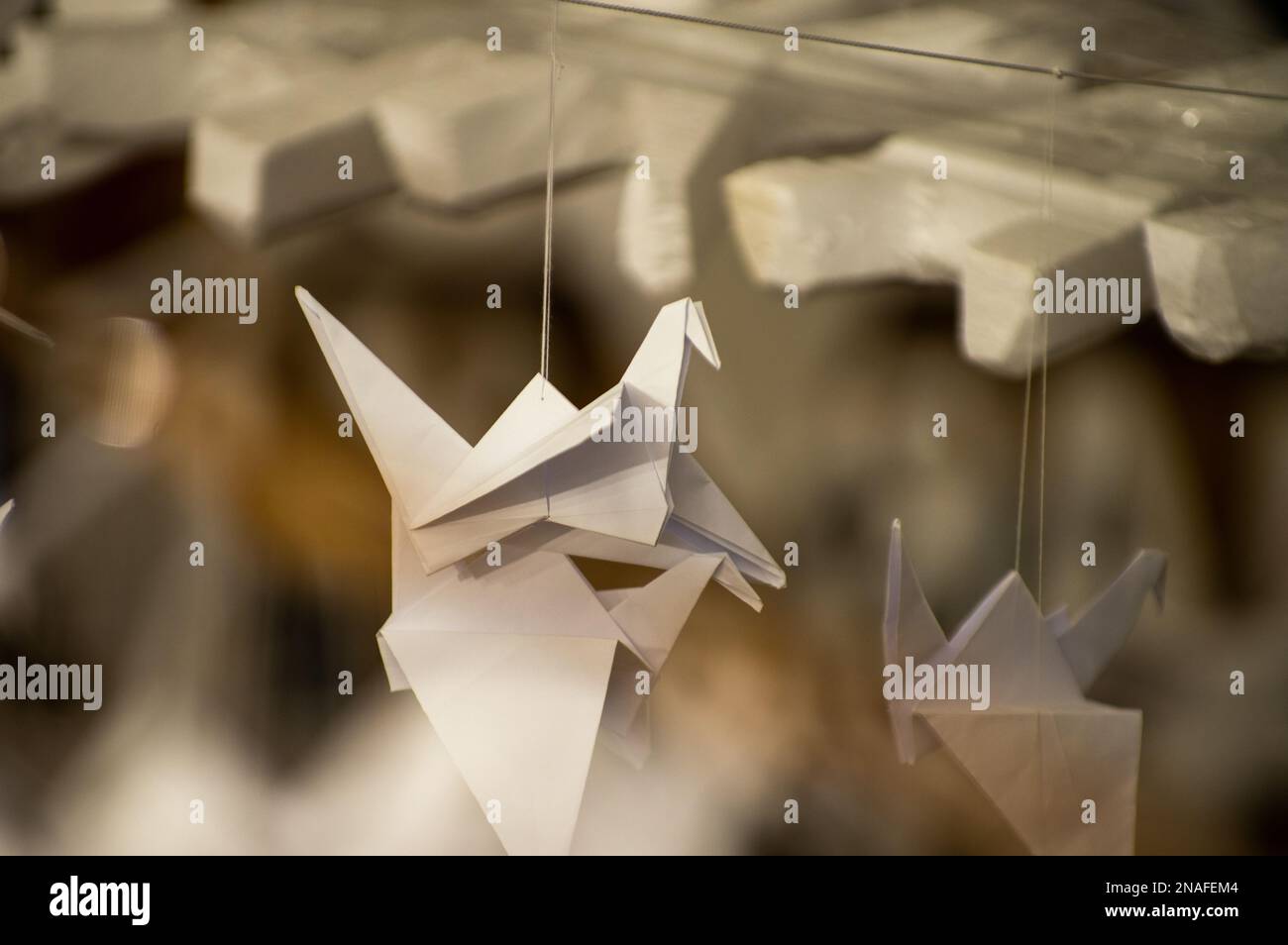 Japanese folded Origami cranes hanging on with strings. Hundreds ...