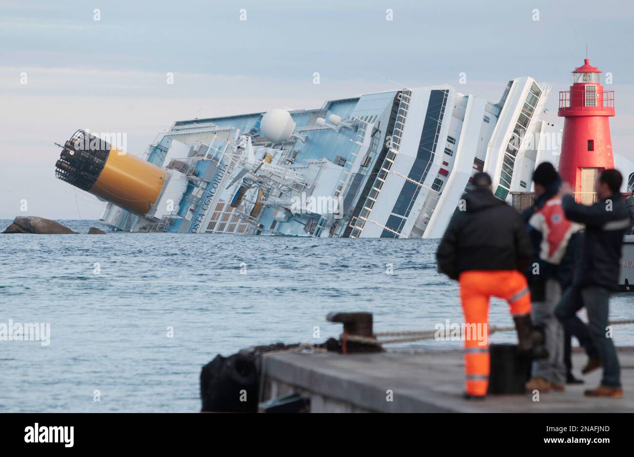 The cruise ship Costa Concordia leans on its side off the tiny Tuscan ...