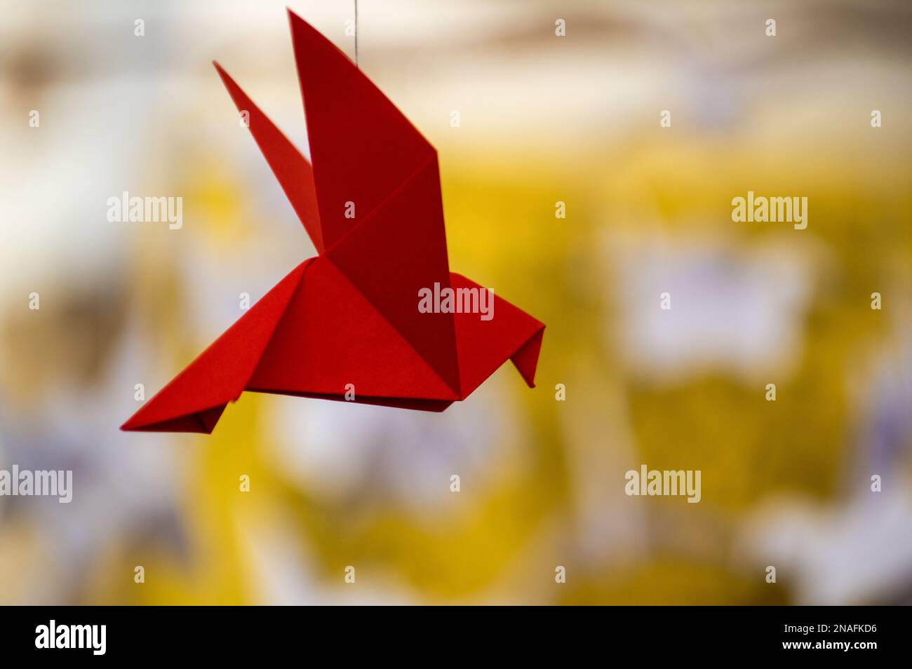 Japanese folded Origami cranes hanging on with strings. Hundreds ...