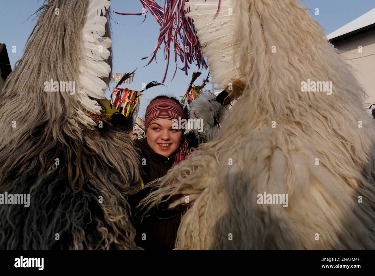 Fur-costumed revellers at a spring festival surround a woman during ...