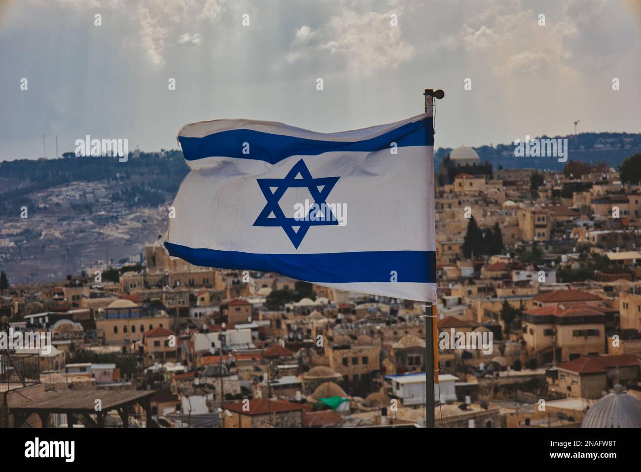 A close-up shot of the flag of Israel with the old city in background ...