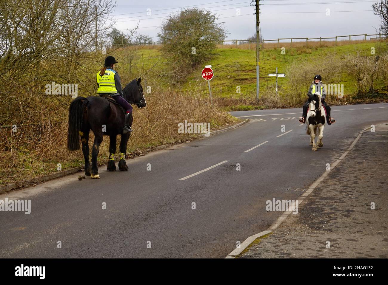 Two female horse riders meet on a road in New Mills, Derbyshire Stock ...