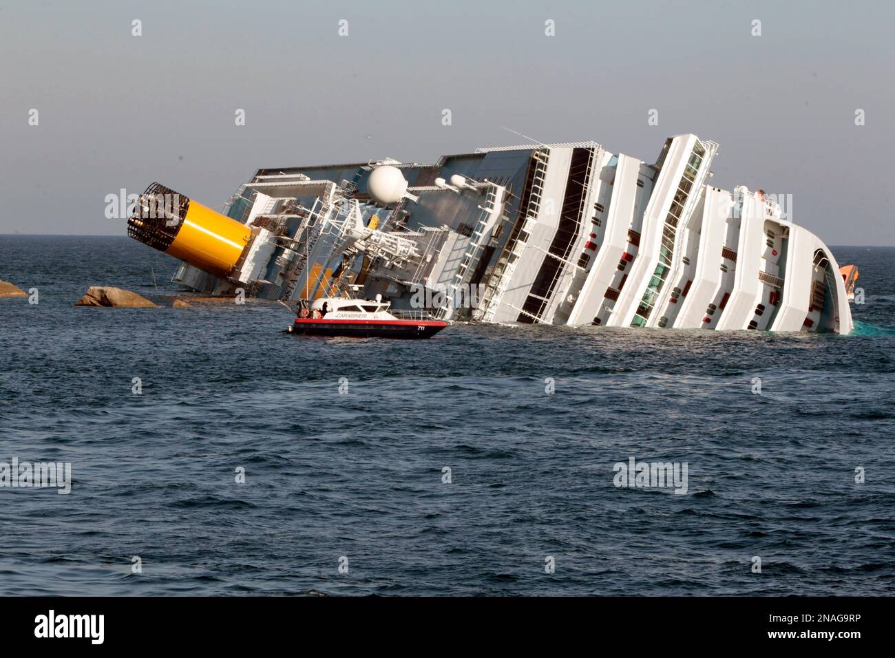 A Carabinieri boat approaches the luxury cruise ship Costa Concordia ...