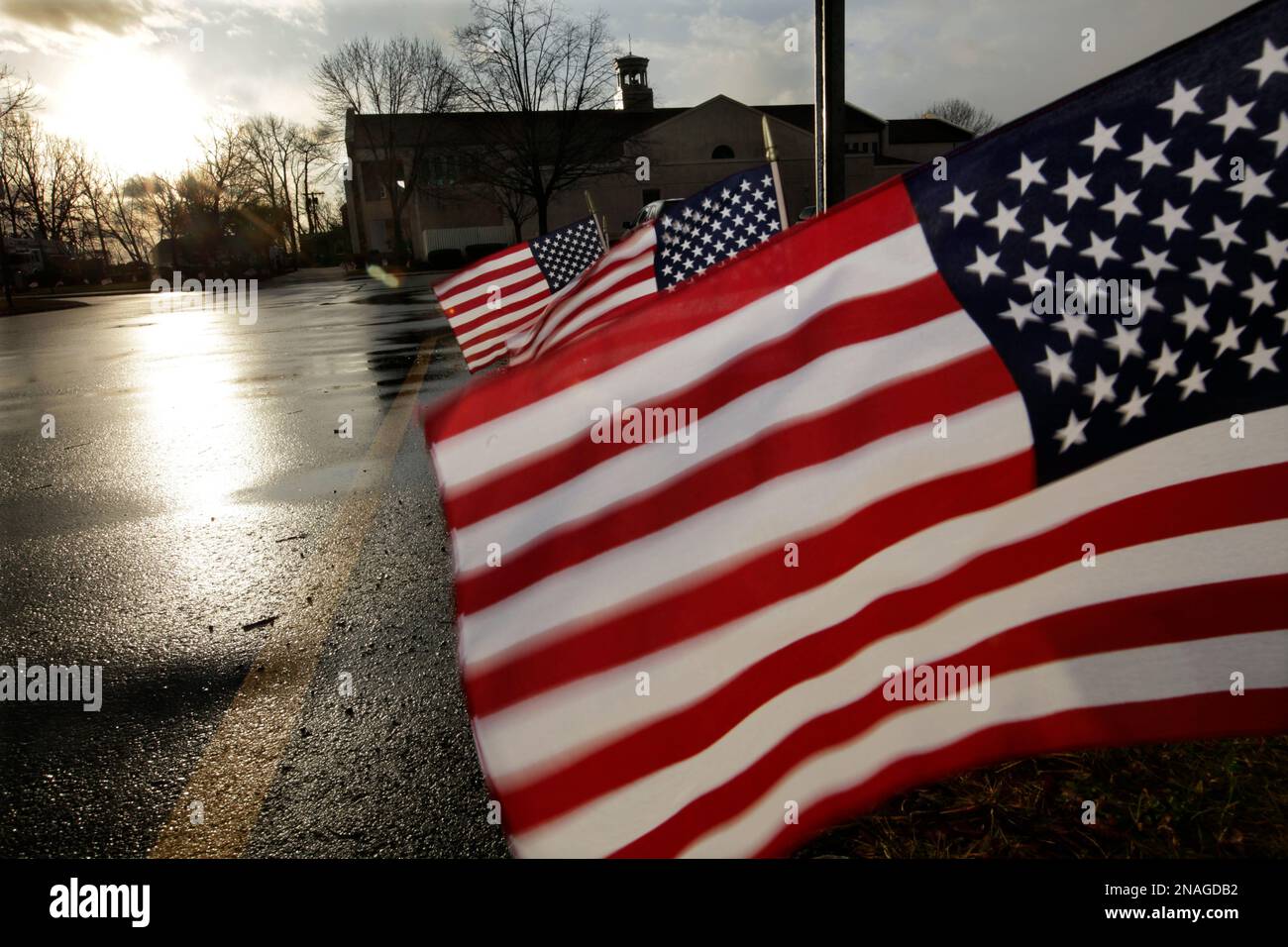 American flags line the walk outside St. Peter The Apostle Church in ...