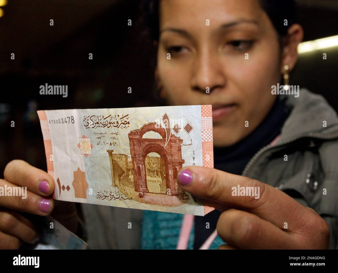 Sauda Omar, a Filipino woman arriving from Syria, shows a Syrian bill ...