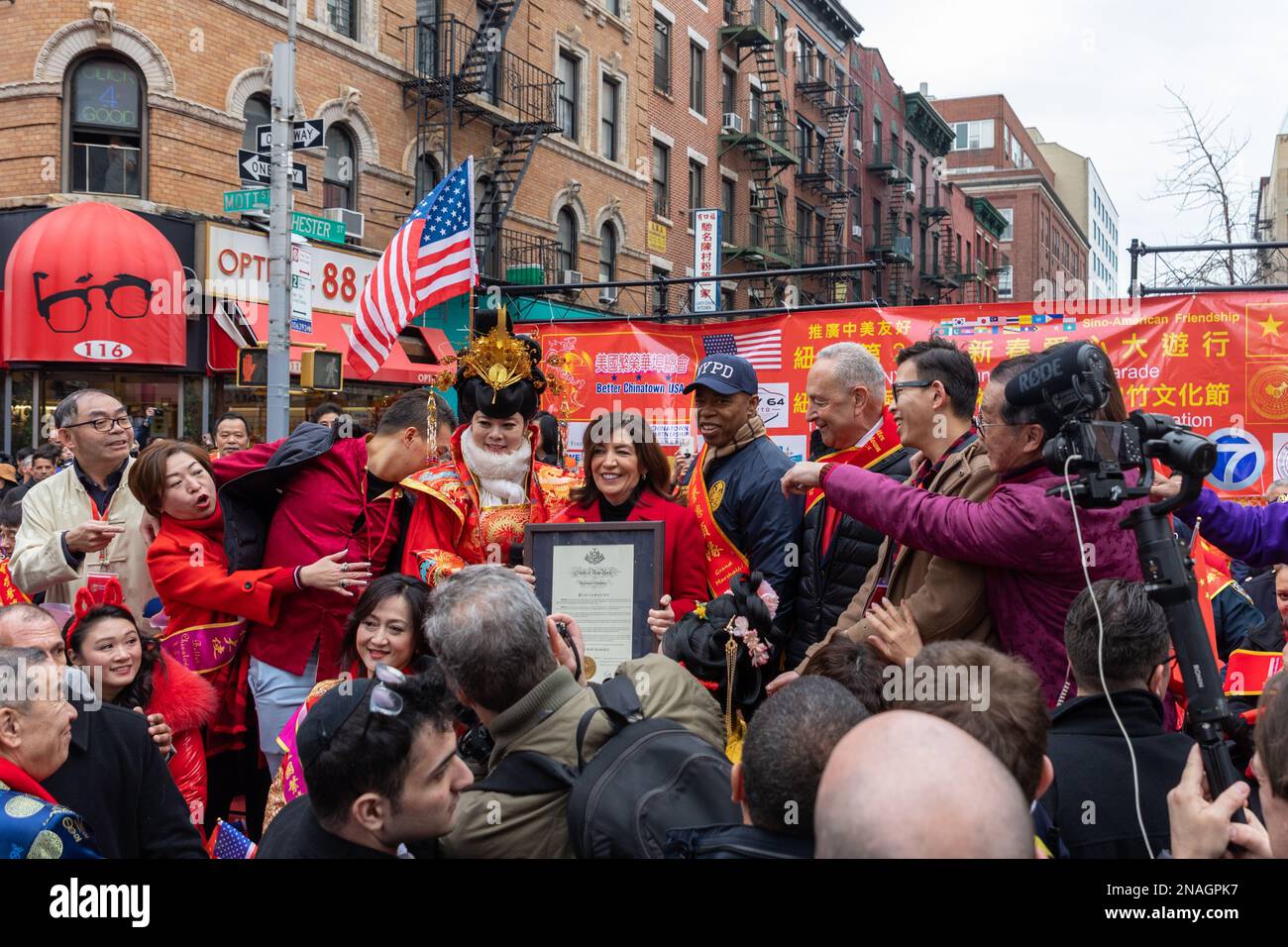 A group of people taking pictures while proudly waving flags and ...