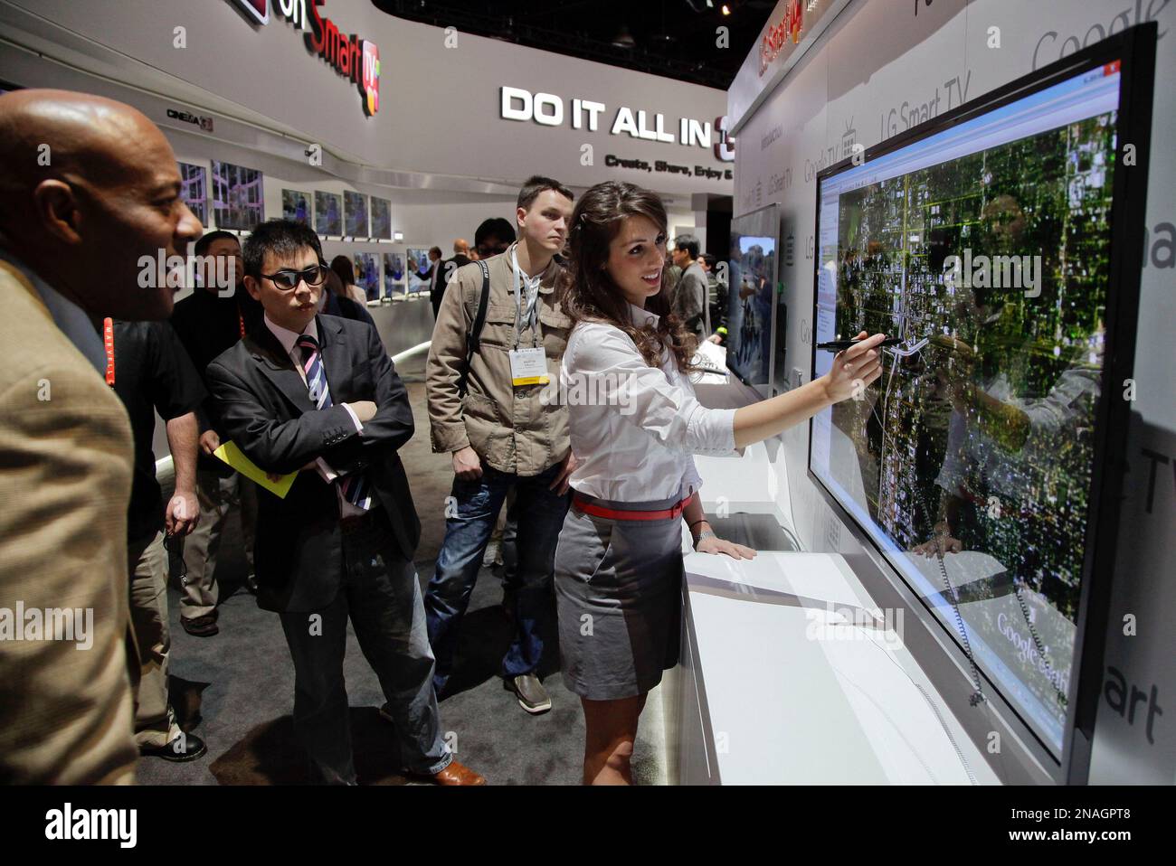 LG exhibitor Amanda Musso demonstrates a touch screen tv to buyers and ...
