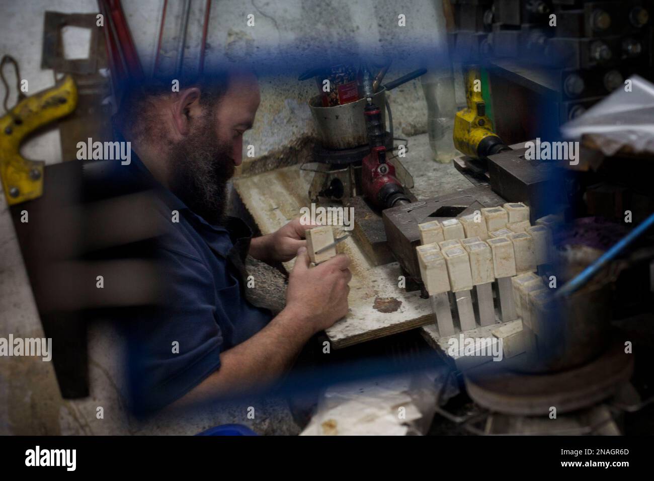 Reflected in a mirror, an Ultra Orthodox Jewish man prepares sets of ...