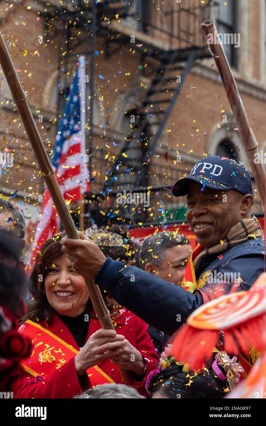 A group of people walking down a street in a celebratory parade under ...