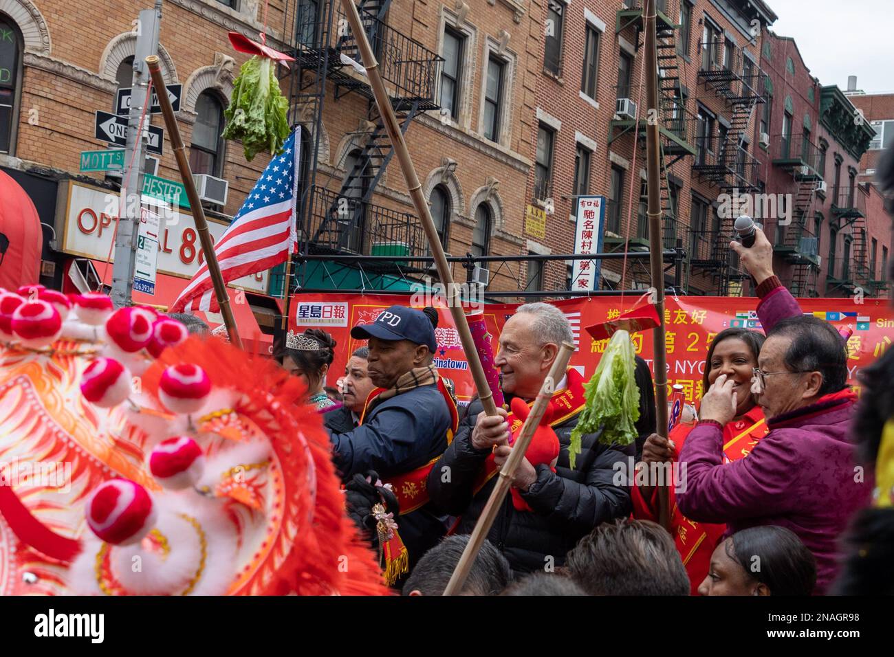 A group of people proudly marching down a city street, waving a ...