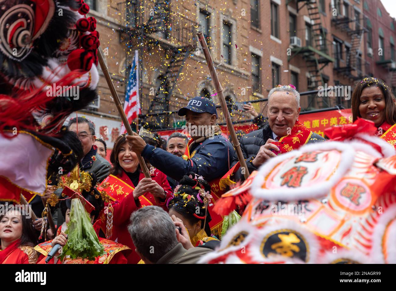 A group of people walking down a street in a celebratory parade under ...