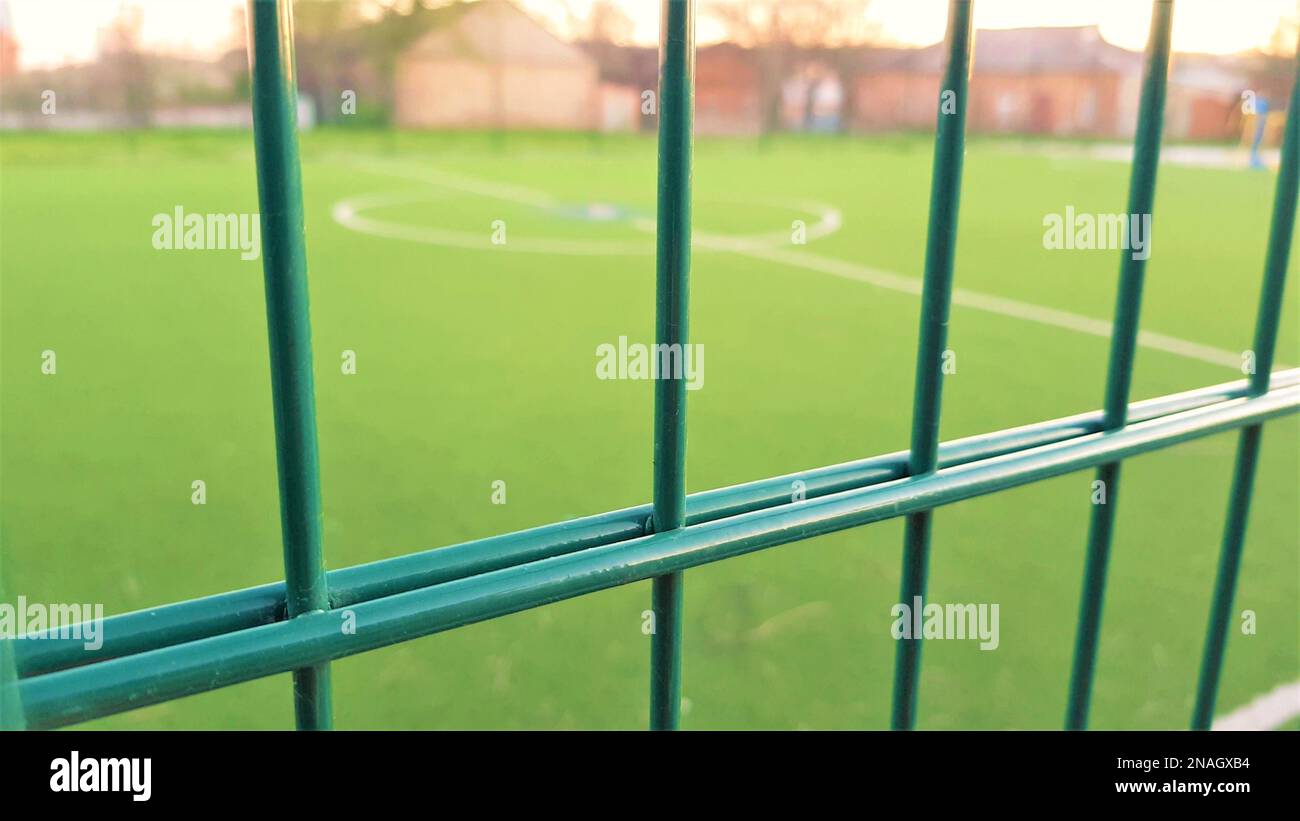 lawn field for playing minifootball behind the green fence mesh Stock ...