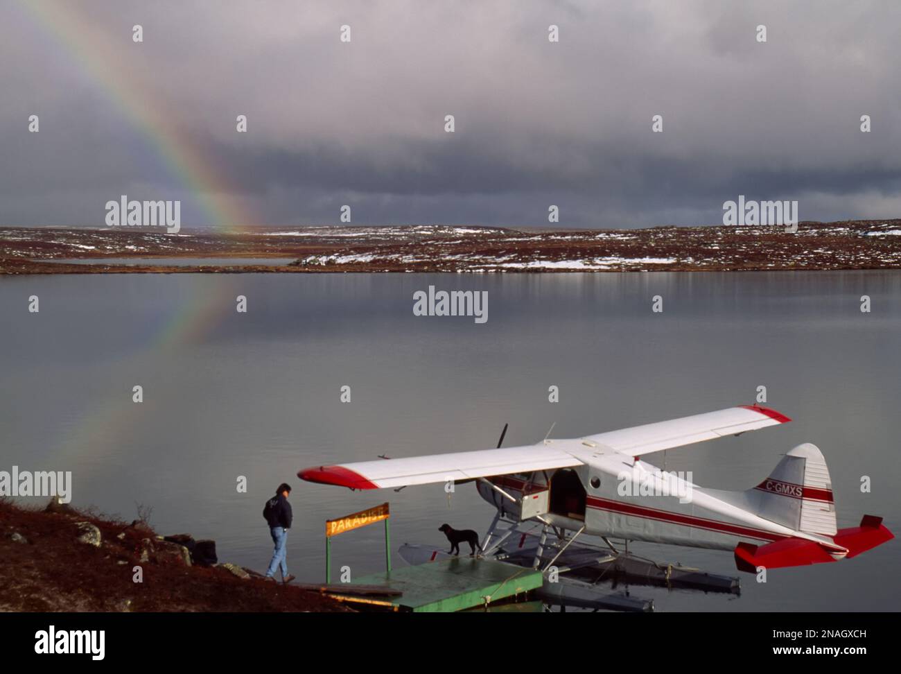 A floatplane brings supplies to a diamond mining camp under a rainbow ...