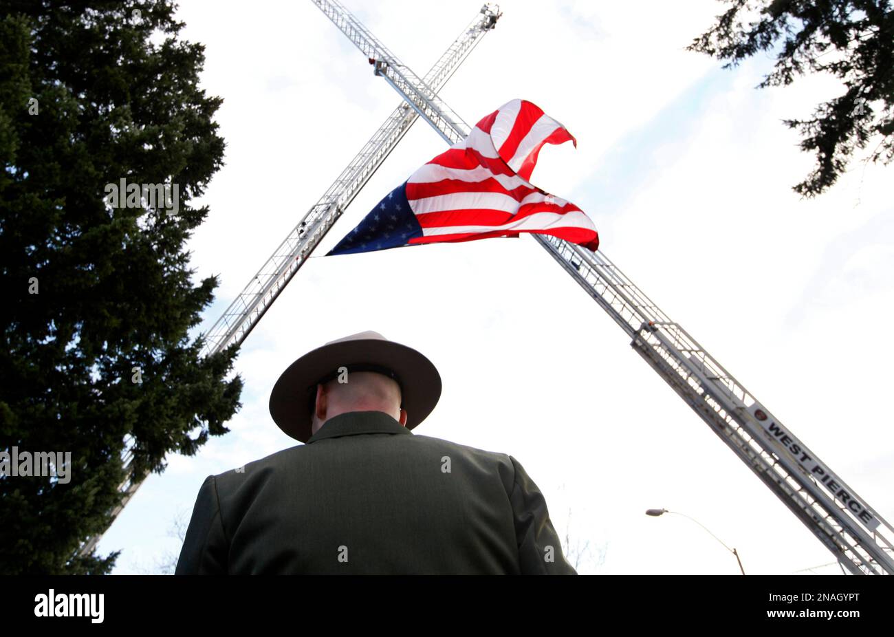 A National Park ranger stands beneath a giant U.S. flag over the ...