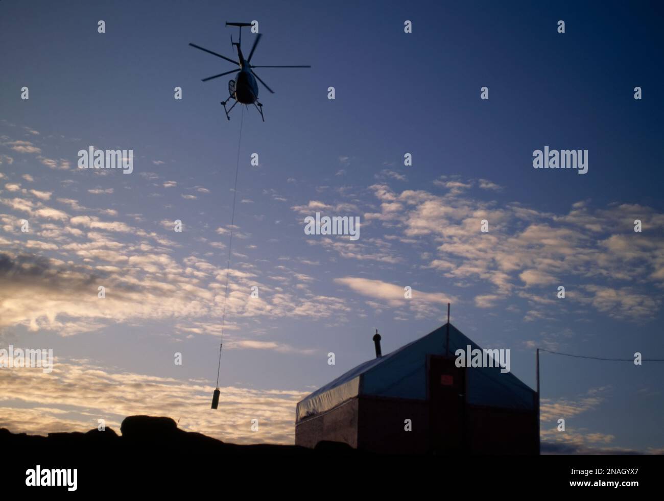 Helicopter with a load hovers at a diamond mining camp; Yellowknife ...