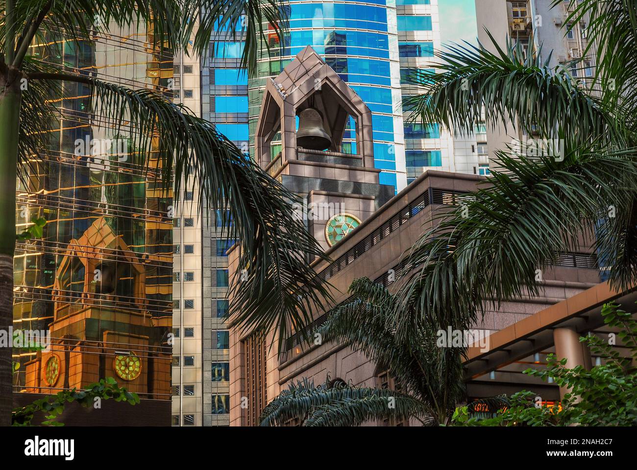 An old sandstone building with a bell tower is reflected in the windows ...