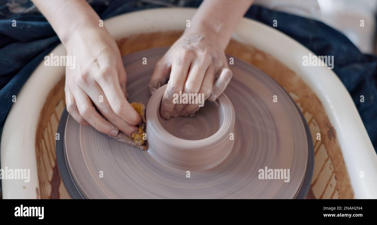 Pottery, art and hands on a potter wheel with artist spinning clay in ...