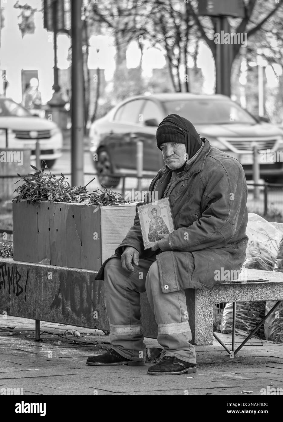 Bucharest, Romania - 12.29.2022:Homeless senior man holding a religious ...