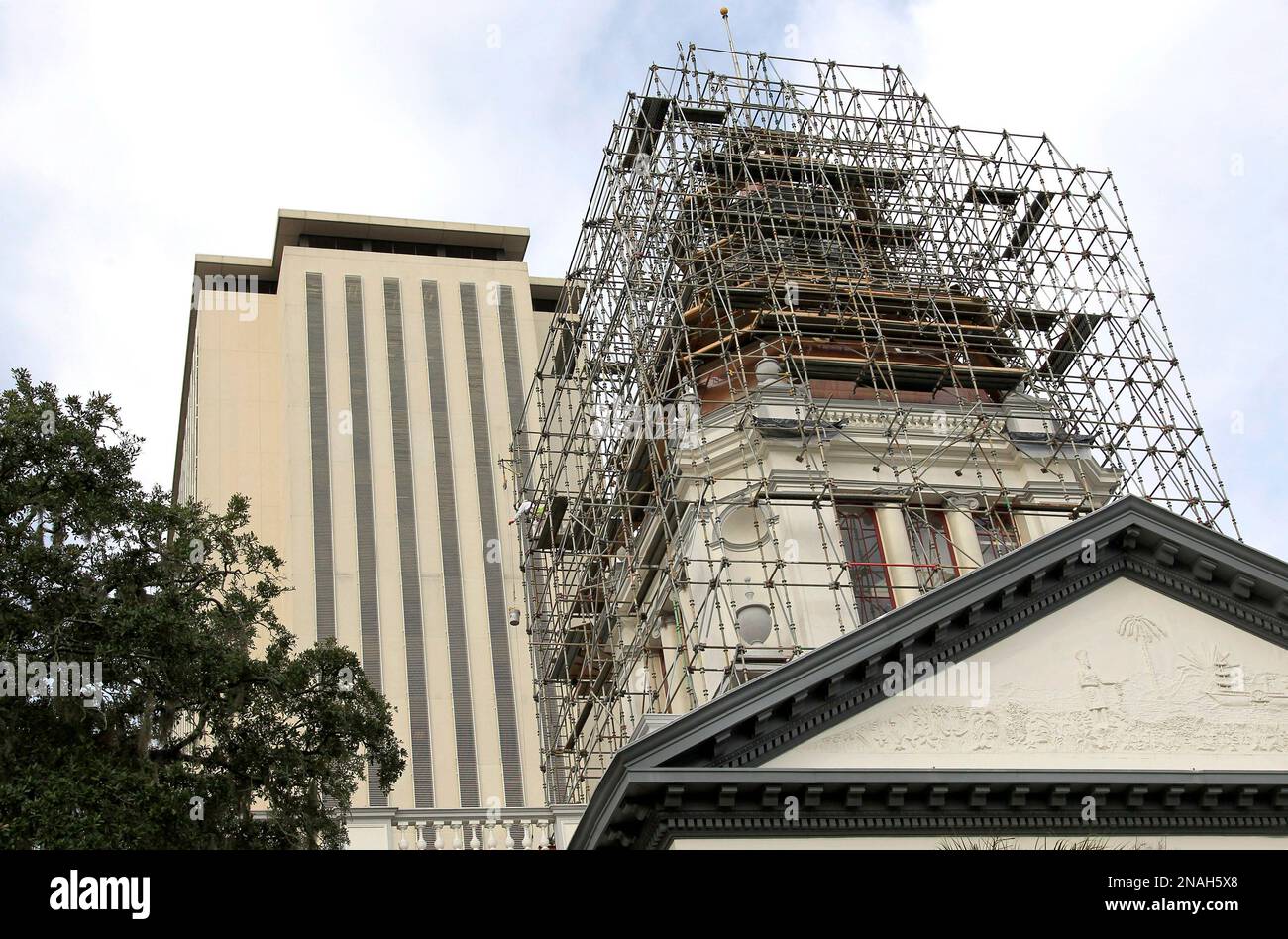 Workers, surrounded by safety scaffolding, replace the roof on the Old ...